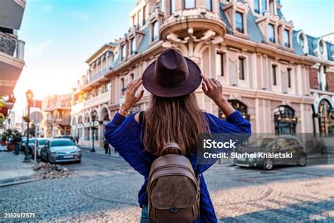 캐주얼 스타일리시한 패셔너블한 힙스터 여행자 모자와 갈색 배낭을 들고 혼자 유럽 도시를 걷고 있는 여자 여행 주제에 대한 스톡 사진 및 기타 이미지 Istock