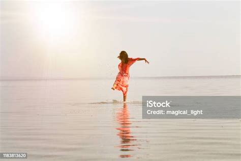 해변에서 아름다운 여자 매력적인 슬림 모델은 여름 휴가를 즐기는 핑크 드레스를 입고 아름다운 젊은 웃는 소녀는 바다에서 물을