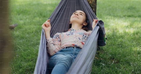 여름 공원에서 피크닉을 할 때 나무 사이에서 해먹에서 휴식을 취하고 차가워지는 젊은 여성 사회적 거리 두기 솔로 야외 활동 뉴노멀 안전 모임의 레저 사진