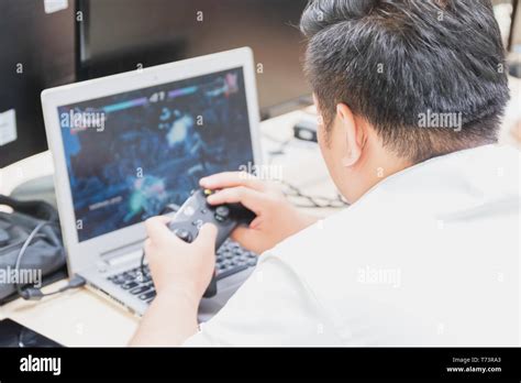 Back Of Asian University Student Playing Game In The Classroom During