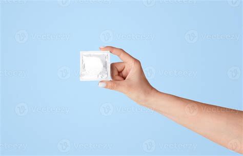 Safe Sex Millennial Girl Showing Condom With Wrapper On Light