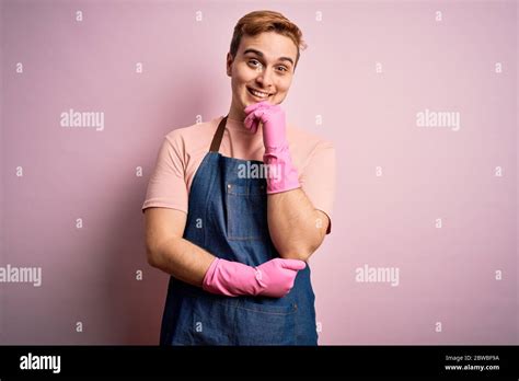 Young Handsome Redhead Cleaner Man Doing Housework Wearing Apron And