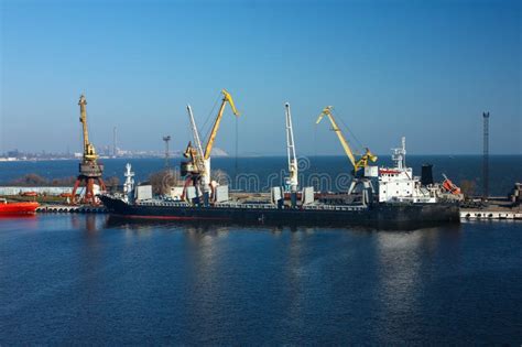 Cargo Ship Loading At The Dock With Multiple Cranes Industrial Transshipment Process In A Sea