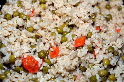 얇게 썬 양파를 곁들인 야채 완두콩과 당근을 곁들인 뜨거운 찐 흰 쌀밥의 클로즈업 중국 요리 조리법 및 동양 아랍어와 중국