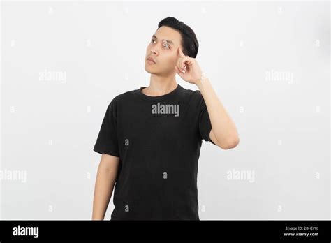 Young Asian Man With Black Shirt Having Doubts And With Confuse Face Expression While Scratching