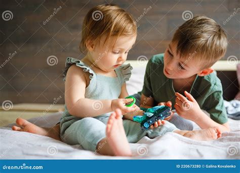 La Hermanita Juega Con Su Hermano Mayor En Casa Foto De Archivo Imagen De Hija Sitio