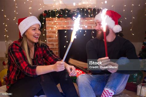 폭죽 포옹 하 고 집에서 크리스마스를 축 하 하면서 웃 고 들고 행복 한 젊은 커플 2명에 대한 스톡 사진 및 기타 이미지 2명 가정 생활 가정의 방 Istock
