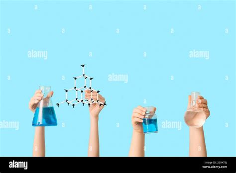 Female Hands Holding Molecular Model And Filled Flasks On Blue Background Chemistry Lesson