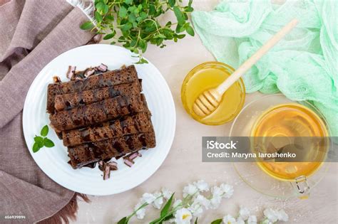 얇은 섬세한 초콜릿 팬케이크는 흰 접시에 더미에 깔려 있고 꿀을 곁들인 허브 티 한 잔에 놓입니다 맨 위 보기 갈색에 대한 스톡 사진 및 기타 이미지 Istock