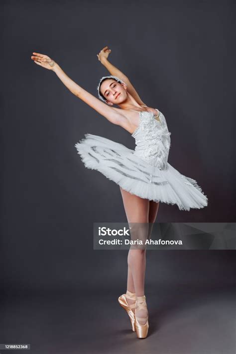 전문 적인 복장 뾰족한 신발 흰색 투투를 입은 젊은 우아한 발레리나는 댄스 실력을 보여줍니다 포토 스튜디오에서 회색 백그룽에 고립 된 아름다운 클래식 발레 댄서
