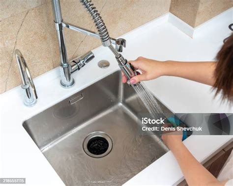 유연한 수도꼭지 분무기와 파란색 스폰지를 사용하여 스테인리스 스틸 주방 싱크대를 청소하여 위생과 청결을 보장하는 사람 가정 주방에 대한 스톡 사진 및 기타 이미지 Istock