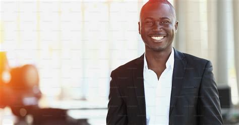 작업 환경에서 카메라를 보고 있는 아프리카계 미국인 비즈니스 리더의 이미지 사진 Unsplash의 전경에 초점 맞추기 이미지