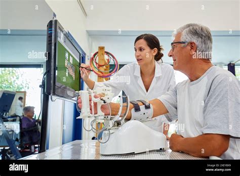 Therapist And Patient With Assistive Robot For Upper Limb Rehabilitation The Robot Armassist