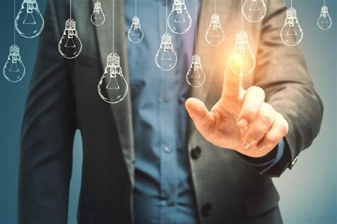 Premium Photo Close Up Of Businessman Hand Pointing At Glowing Drawn Lamps On Gray Wallpaper