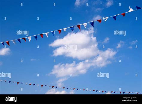 Colourful Decorative Triangular Flags Under Blue Sky With Clouds Sunny