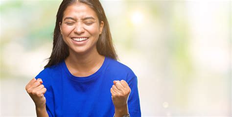 젊은 아름 다운 아랍 여자 격리 된 배경에 매우 행복 하 고 흥분 무기와 우승자 제스처를 하 고 웃 고 성공을 위한 비명 축 하 개념입니다 긍정적인 감정 표현에 대한 스톡