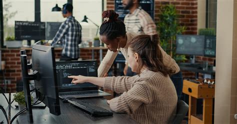 Two Software Coders Analyzing Source Code Looking For Errors Running On
