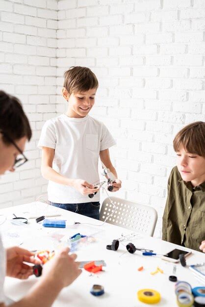 Premium Photo Young Boys And Having Fun Constructing Robot Cars