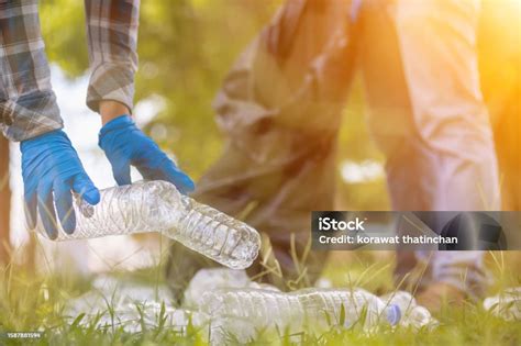 남자들은 공원의 잔디밭과 산책로에서 플라스틱 병을 모아 가방에 넣어 깨끗하게 유지합니다 재활용을 통한 환경 문제 감소 2명에 대한 스톡 사진 및 기타 이미지 Istock