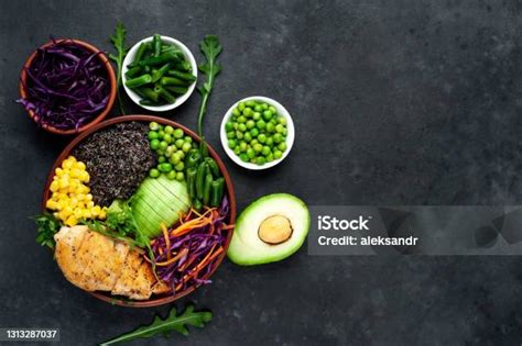 그릇 부처님 퀴노아 닭 가슴살 아보카도 붉은 양배추 아루굴라 당근 녹색 완두콩 옥수수 브로콜리 석조 배경에 접시에 녹색 콩 텍스트 복사 공간 건강한 식생활에 대한 스톡 사진