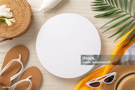 해변에서 휴식을 취하세요 위에서 본 액세서리 선글라스 모자 등나무 가방 샌들 자외선 차단제 병 수건 알스트로에메리아 야자수 잎 텍스트 또는 광고를 위한 빈 원이 있는 모래