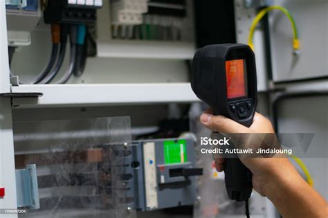 전문 전기 기술자는 예방 유지 보수 산업용 열화상 촬영 전력 전기의 열 이미지를 위해 열 적외선 카메라 또는 온도계 스캔 전기