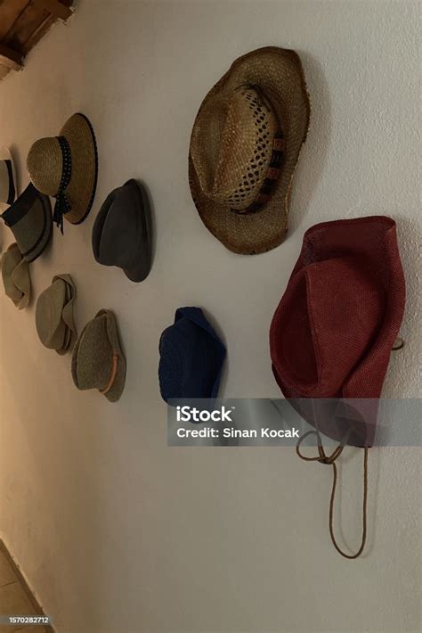 나무 천장이 있는 오래된 집 방 홀의 흰 벽에 걸린 모자 남성과 여성을 위한 빈티지 클래식 시대를 초월한 패셔너블한 스타일의 모자 매달기에 대한 스톡 사진 및 기타 이미지
