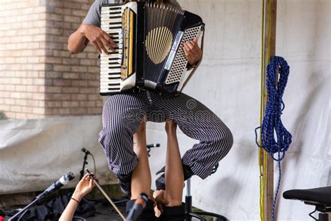 Mujer Jugando Al Acordeón Y Sentada En Las Piernas Foto De Archivo