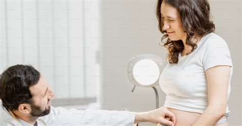 진료실에서 진찰 중 임산부의 배를 테이프로 측정하는 남성 의사 임신 중 의료와 건강의 개념 사진 Unsplash의 성인 이미지