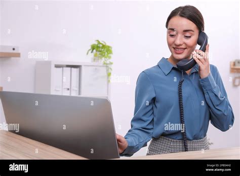 Female Receptionist Talking On Phone At Workplace Stock Photo Alamy