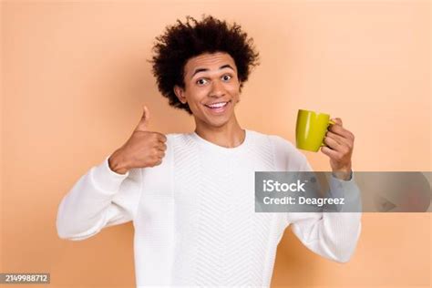 사진 만족스러운 좋은 남자 입고 있다 유행 옷 손 잡다 머그잔 공시하다 맛있는 향기 음료 엄지 손가락 베이지 색 배경에 고립 된 20 24세에 대한 스톡 사진 및 기타
