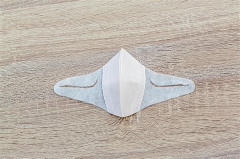 나무 테이블에 보호 얼굴 마스크 입과 코를 덮는 전형적인 3ply 수술 마스크 박테리아에서 절차 마스크 보호 개념입니다 고무 귀