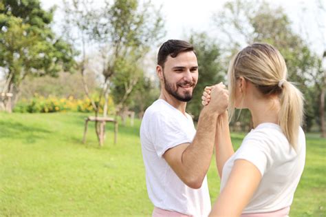 자연에 녹색 나무와 공원에서 미소와 팔 레슬링 도전흰색과 분홍색 스포츠 드레스에 젊은 백인 부부의 이미지 귀여운에 대한 스톡 사진 및 기타 이미지 Istock