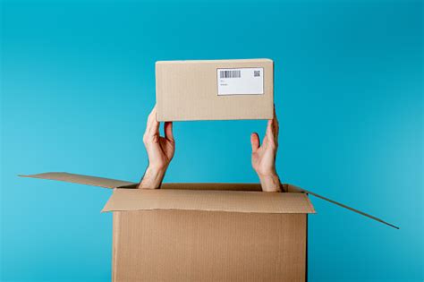 파란색으로 분리 된 패키지에서 골판지 상자를 들고 택배의 자른 보기 Qr코드에 대한 스톡 사진 및 기타 이미지 Qr코드