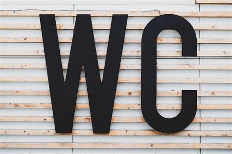 목재 판넬로 건물 외관에 큰 글자 Wc 도시 공원에서 공중 화장실 기호입니다 국제 화장실 기호 야외 화장실 화장실 프리미엄 사진