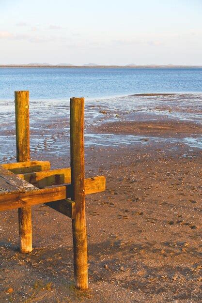 Premium Photo Wooden Posts On Beach Against Sky