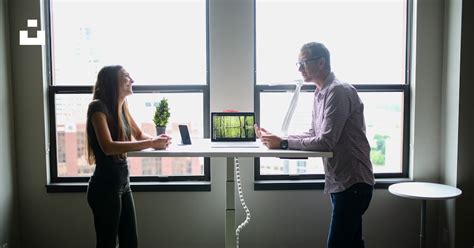 회색 드레스 셔츠를 입은 남자가 검은 탱크 탑에 여자 옆에 서 있다 사진 Unsplash의 무료 직업 이미지