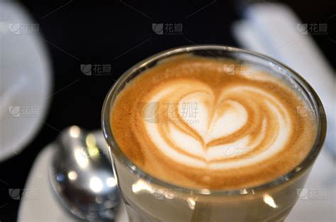 一杯白色杯子里有心形图案的咖啡