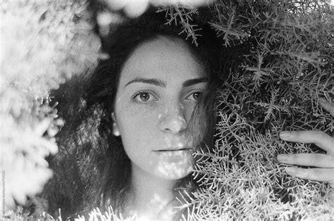Woman Peering Through Branches By Stocksy Contributor Anna Malgina