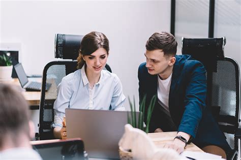 웹 사이트에 튜토리얼을보고 무선 인터넷 연결과 현대 노트북 장치에 작업 계획을 논의 하는 남성과 여성 동료 사무실에서 앱 공동 작업을 설치하는 두 명의 It 개발자 2명에