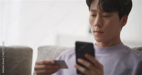 거실 소파에 앉아 스마트폰으로 온라인 쇼핑을 하는 남성의 상반신 Vídeo Do Stock Adobe Stock