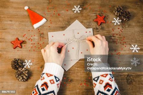 세련 된 크리스마스 플랫 하다 여자 손 잡아 엽서 편지 휴일 축 하 개념 여자 니트 스웨터 편지 쓰기에 손 최고의 볼 수 있습니다 갈색에 대한 스톡 사진 및 기타 이미지