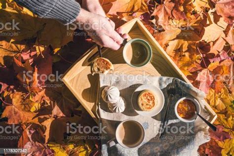화려한 단풍 잎과 가을 정원에서 아침 식사를 하는 남자와 여자의 커플 커피 한 잔 마시멜로 잼 치즈 팬케이크를 나무 트레이에 얹어 놓습니다 공중 보기 가을에 대한 스톡 사진