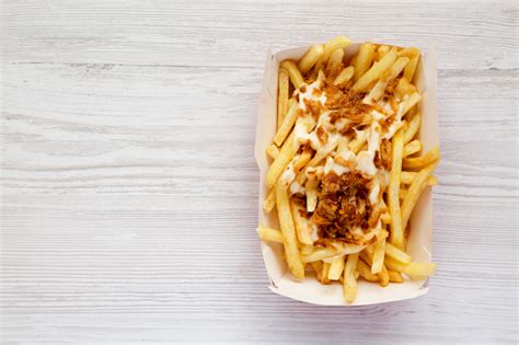 머리 위 전망 치즈 소스를 곁들인 감자 튀김 흰 나무 표면에 종이 상자에 튀긴 양파 평면 누워 위에서 상단보기 공간을 복사합니다 감자 요리에 대한 스톡 사진 및 기타 이미지