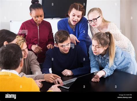 happy classmates having difficult project to complete during class sits