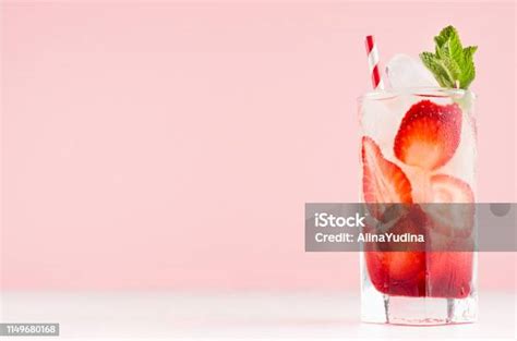 부드러운 현대 분홍색 배경에 향신료 열매 얼음 조각 민트와 줄무늬 밀 짚과 신선한 딸기 칵테일 복사 공간 0명에 대한 스톡 사진