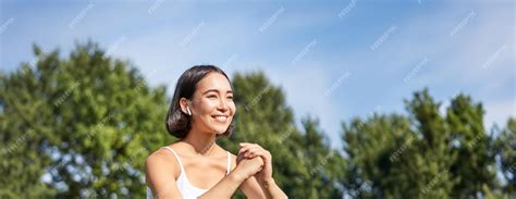 Free Photo Asian Fitness Girl Doing Squats In Park Using Resistance
