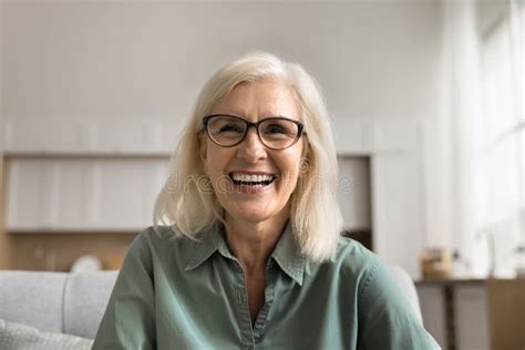 Older Woman Engaged In Joyful Conversation Through Video Call Stock