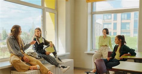 A Group Of Girls Sitting On A Window Sill Photo Classroom Fashion Image On Unsplash