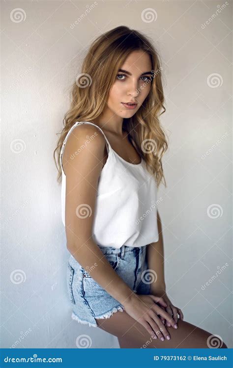 Young Model Girl In White Tank Top And Short Blue Jean Shorts Stock
